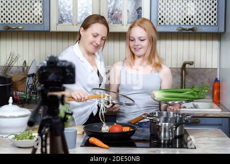 mom and daughter are recording a funny cooking show. food vlogging ...