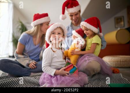 Cheerful parents spening Christmas time together with their kids ...