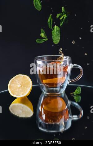tea leaves falling into tea cup, on white background Stock Photo - Alamy