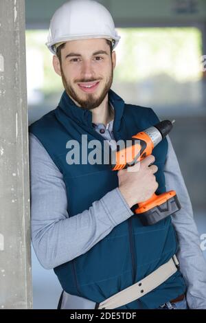 hardworking man pointing at camera with drill Stock Photo - Alamy