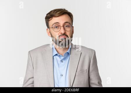 Close-up of reluctant and unamused boss in gray suit and glasses ...