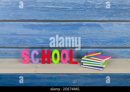 School in colorful letters and notebooks with vintage blue wooden wall ...