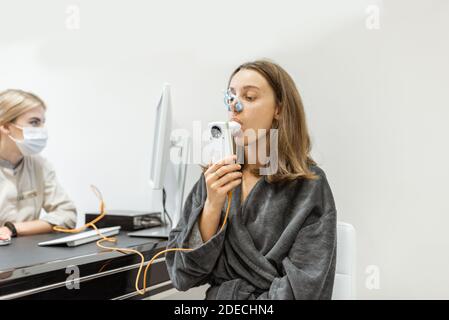 Young woman during a spirography test, measuring breathing movements ...
