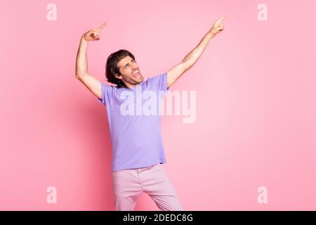 Photo of astonished cheerful man indicate fingers empty space isolated ...