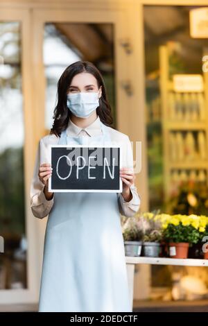 Woman with mask holding chalkboard with open sign Stock Photo - Alamy