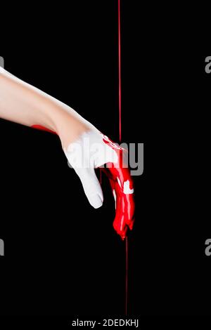 partial view of white painted hand with red dripping paint isolated on ...