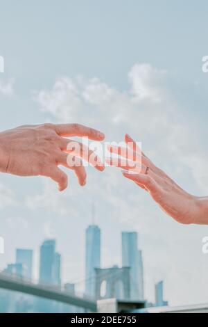 Two hands almsot touching against skyline Stock Photo - Alamy