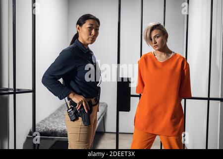 Blonde inmate in an asian women's general security prison is led out of ...