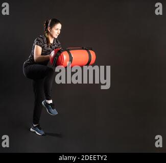 Happy young beautiful woman pulls her hands up, standing on the bed in ...
