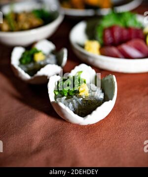 Small raw whitebait fish on a wooden board isolated against white Stock ...