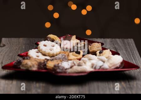 A closeup shot of assorted Christmas cookies on a red tree-shaped plate ...