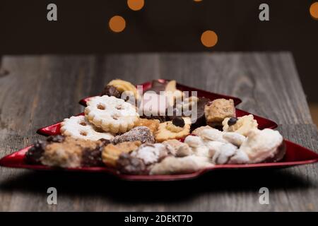 A closeup shot of assorted Christmas cookies on a red tree-shaped plate ...