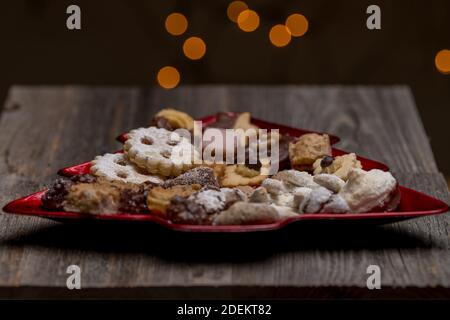 A closeup shot of assorted Christmas cookies on a red tree-shaped plate ...