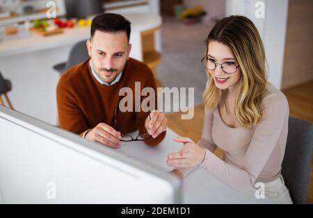 Positive couple having fun while working together remotely at home ...