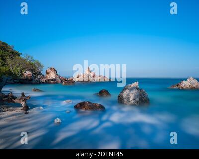 A long exposure of coast and stones under the dramatic view of sunset ...