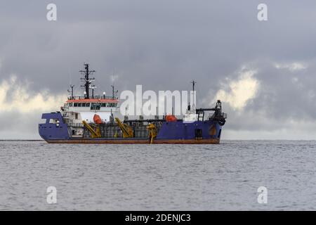 Vessel engaged in dredging. Dredger working at sea. Ship excavating ...