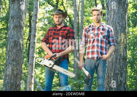 Two ypung Lumberjack man holds axe. Brutal lumberjack concept Stock ...
