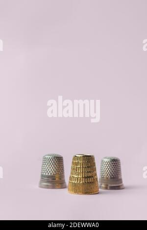 Triangular composition of three thimbles, two types, and one gold on a ...