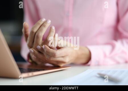 Pain in woman's hand between the fingers is laptop Stock Photo - Alamy