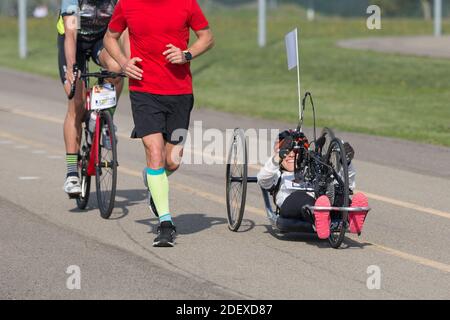 Disabled Athlete who Trains with her Hand Bike with Cyclist and Runners ...