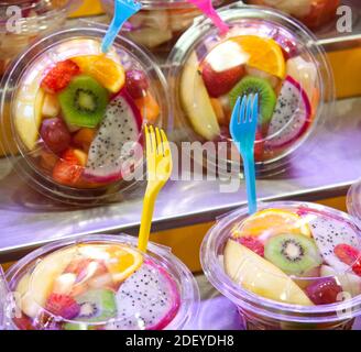 Sliced fresh strawberries in plastic cups with dipping seasoning served ...