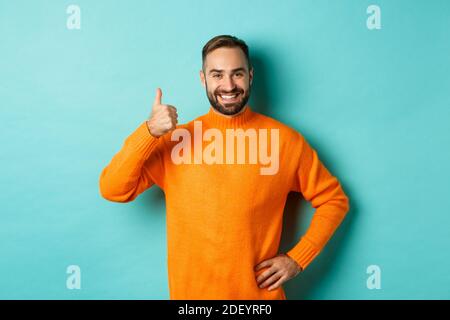 Well done. Handsome bearded man showing thumb up, praising good work ...