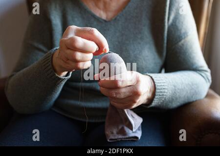 Old woman mending a sock at home Stock Photo - Alamy