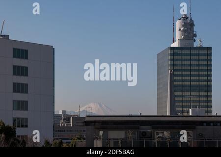 Mount Fuji seen behind buildings and trees in Oshino Hakkai (Oshino ...