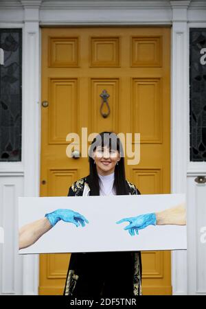Trainee nurse Chloe Slevin, with her painting 'Corona Lisa' showing ...