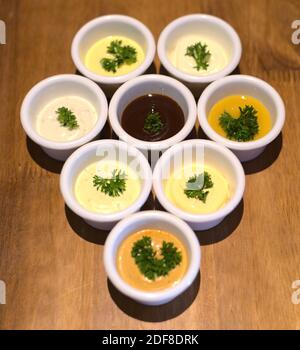 Different types of sauces in bowls on a colored Board . Top view ...
