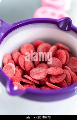 Melting red chocolate melts in the candy melting pot Stock Photo - Alamy