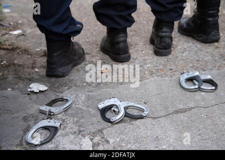 Police officers demonstrate by putting their handcuffs on the ground at ...