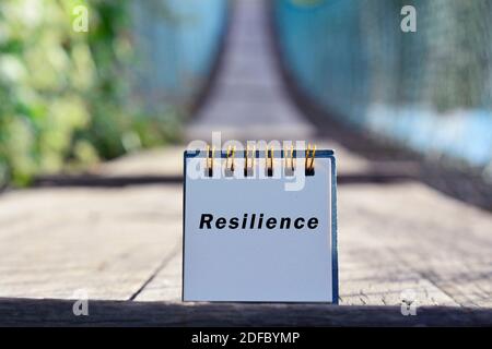 Resilience text written on white note with blurred background of ...