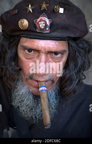 Cuban man with Che beret hat and beard smoking a cigar and clapping in ...