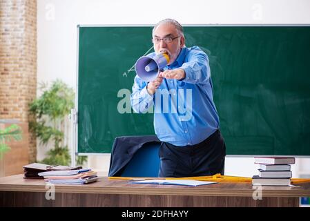 Angry aged male math teacher holding megaphone Stock Photo - Alamy
