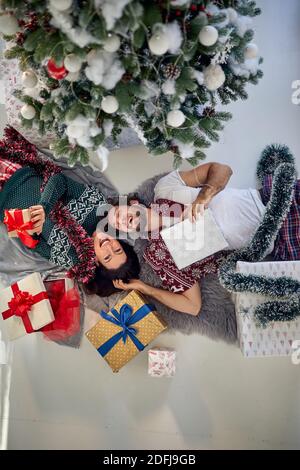 Lovely christmas couple lying with presents Stock Photo - Alamy