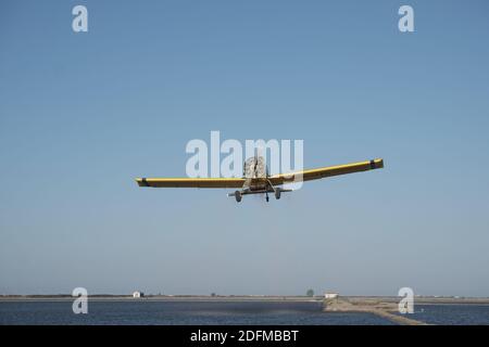 A single-engine propeller airplane flying in a perfectly clear blue sky ...