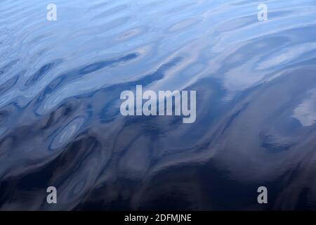 Gentle blue waves, current on water's surface or wake from boat ...
