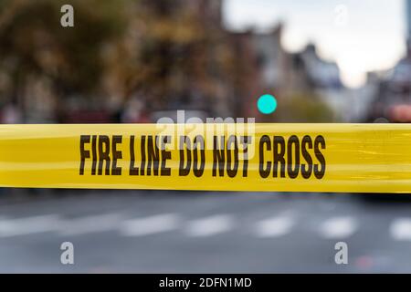 Firefighters install warning hazardous tape around fire scene in the ...