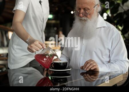 Happy barista in casual red tshirt pointing finger at disposable cup ...
