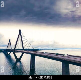 Large highway bridge spanning over a bay, with cars and trucks driving ...