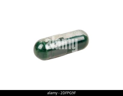 Transparent capsule with medicinal green grass isolated on a white ...