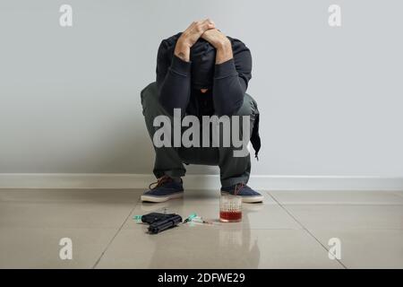 Male junkie with drugs and alcohol indoors. Concept of addiction Stock ...