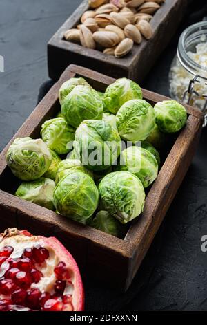 Gnarly garlic brussels ingredient, on black textured background with ...