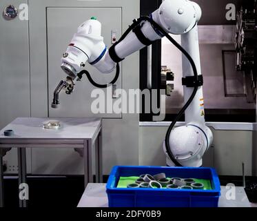 Automated CNC machine loading with robotic arm. Selective focus Stock ...