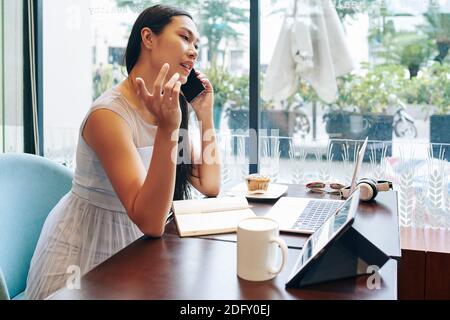 Smiling asian business woman with smartphone in office. Woman in casual ...