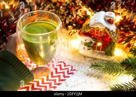 A woman's hand holds a transparent Christmas ball on a white background ...