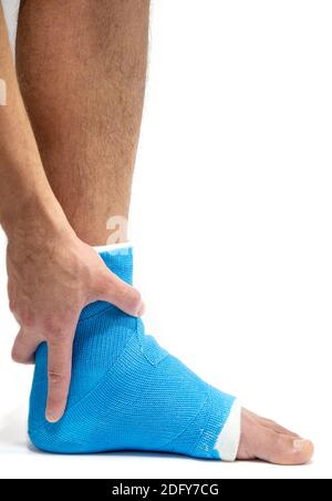 Blue splint ankle. Bandaged leg cast on male patient on light blue ...