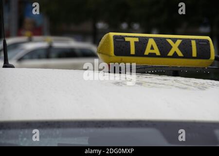 Taxi sign on the road, detail of a text signal in soil, urban transport ...
