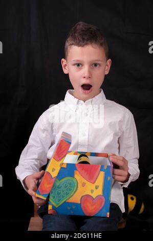 Child with a red packet isolated on green background. Little beauty ...
